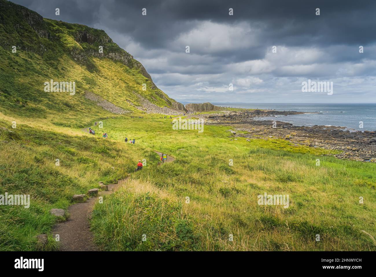 Tourists on path to main hexagonal rock formation, basalt columns in ...