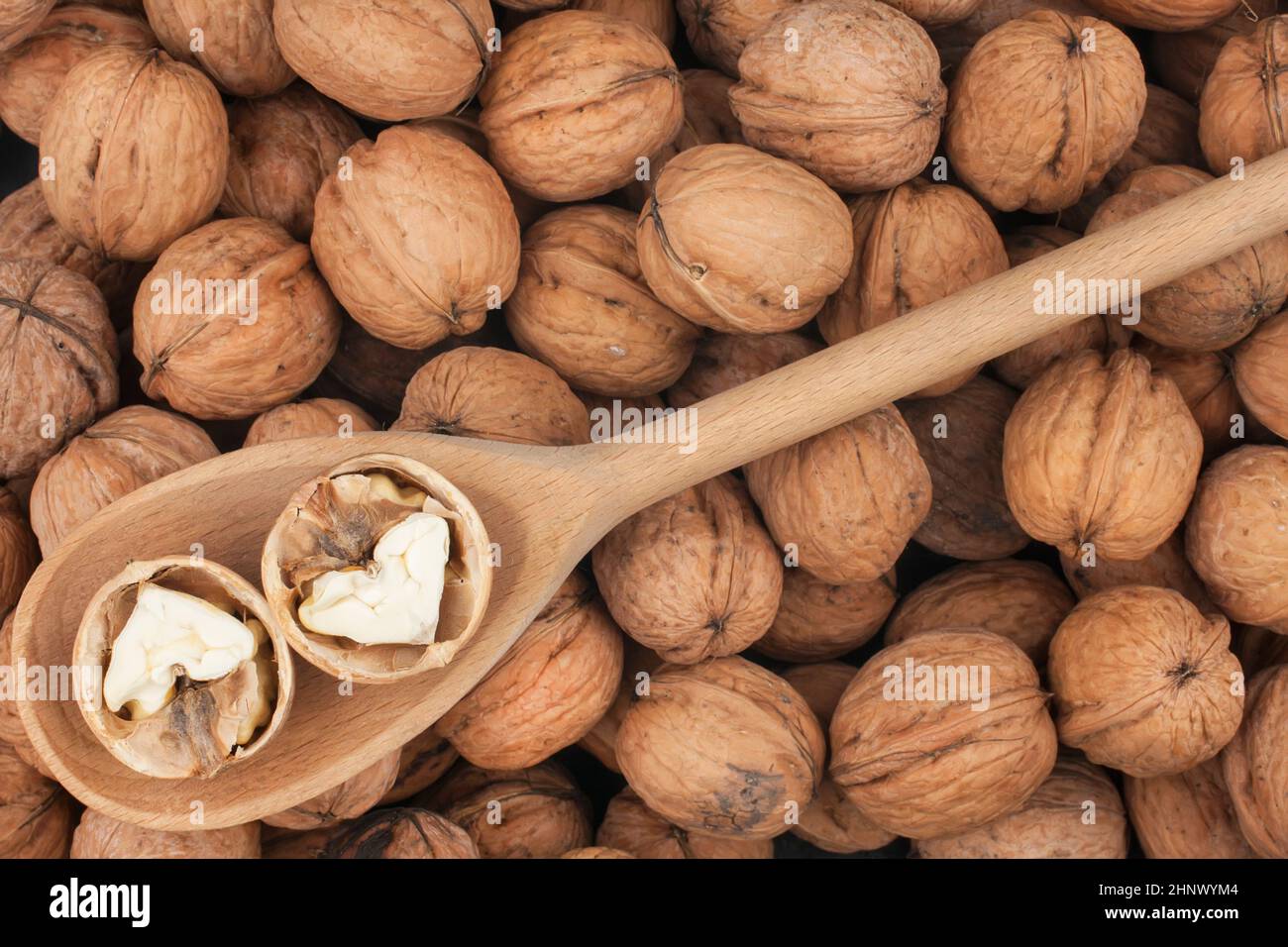 Wooden spoon with walnuts on a background of a walnut Stock Photo - Alamy