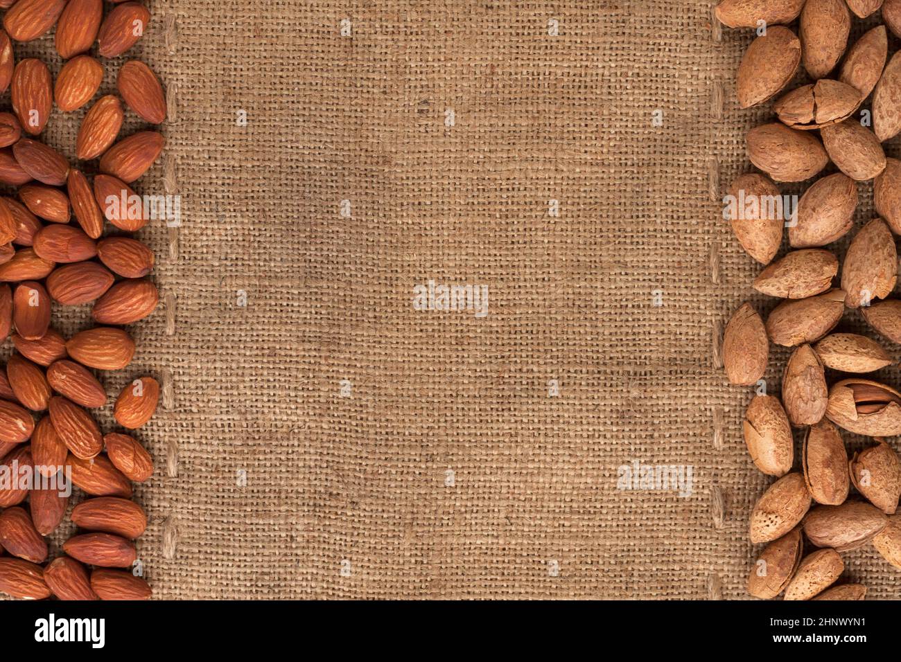 Shelled and unshelled almonds lying on sackcloth can use as background ...