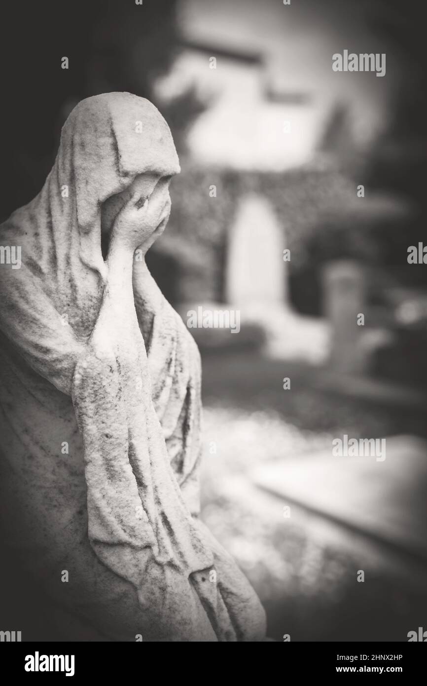 Suffering young woman. Statue of a desperate woman. Defocused blurry ...