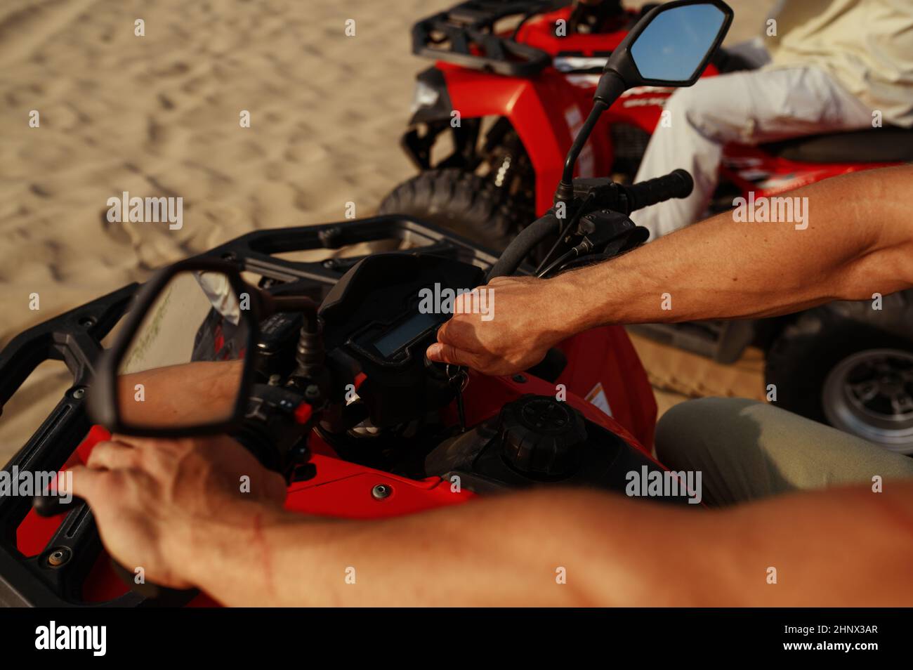 Man rides on atv in desert, closeup view on hands. Male persons on quad ...
