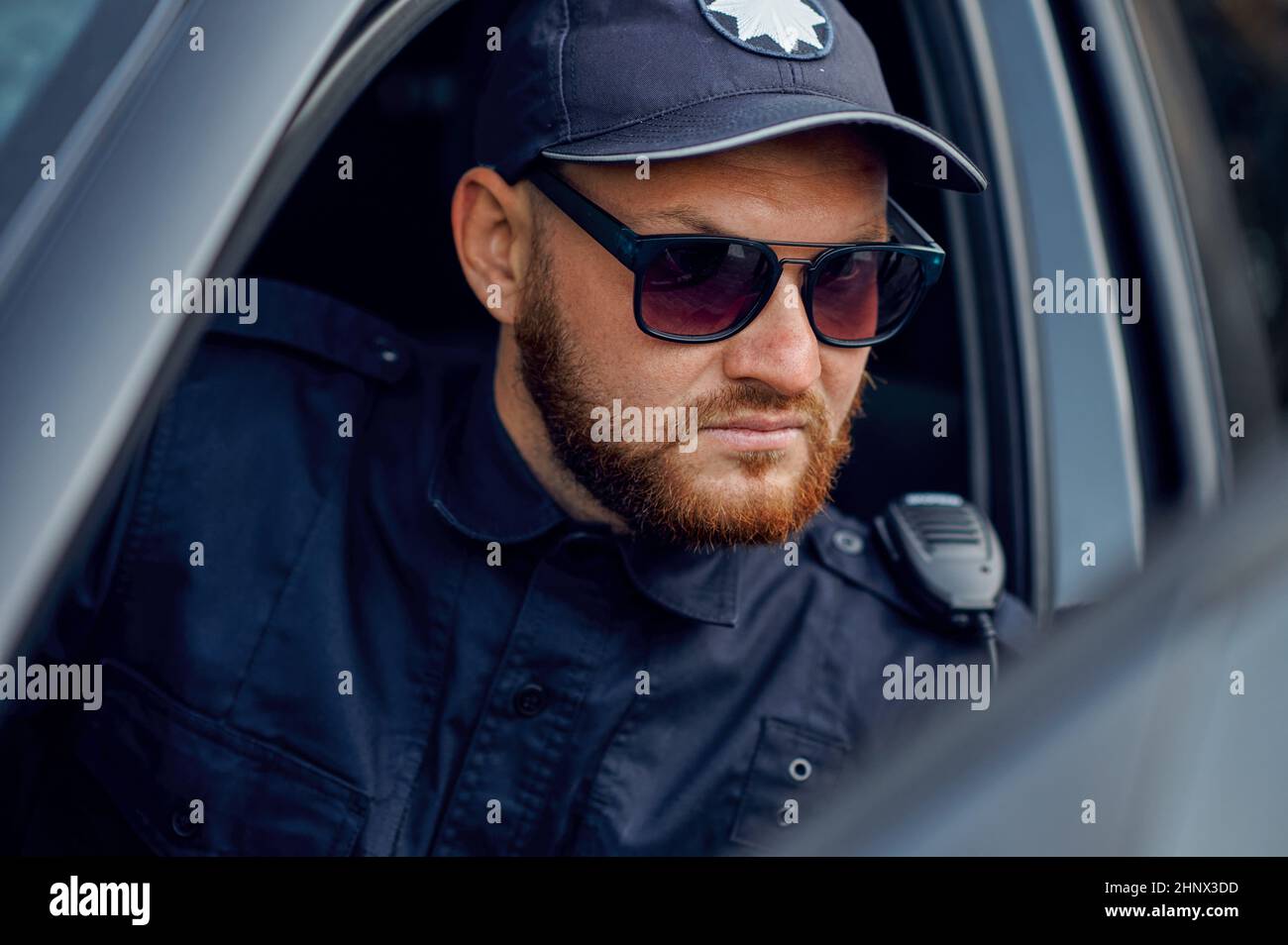 Male police officer in uniform and sunglasses sitting in the car ...
