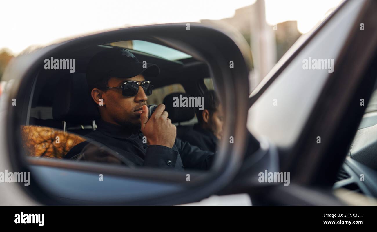Male police officer in uniform and sunglasses talking on a walkie ...