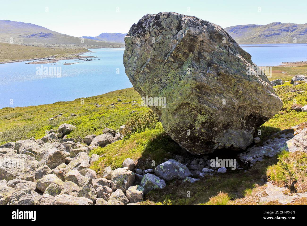 Huge boulder, big rock by the beautiful Vavatn lake in the mountains in ...