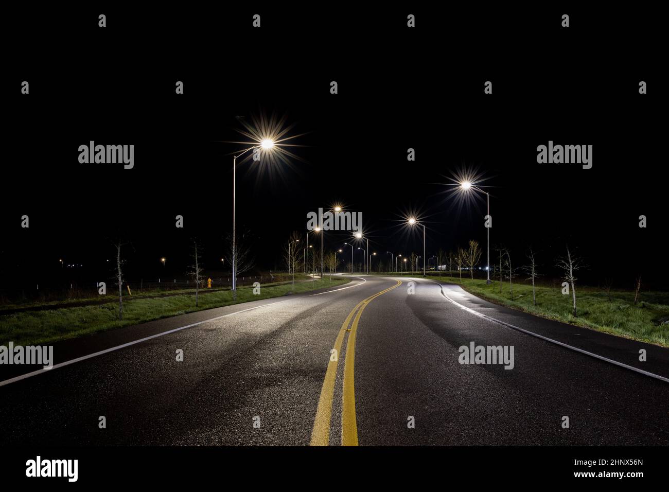 Shot of a clean asphalt road with lights at night Stock Photo - Alamy
