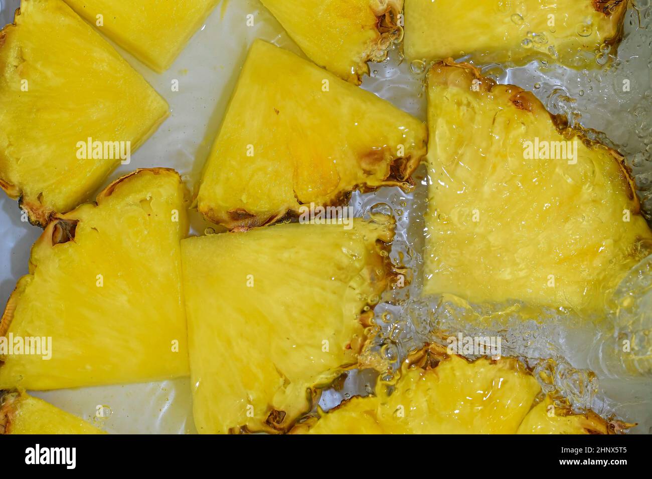Slices of pineapple in water on white background. Pineapple close-up in ...