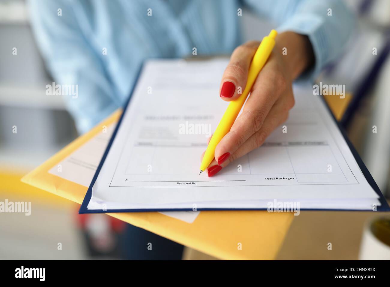 Female hands hold a package and delivery document Stock Photo - Alamy