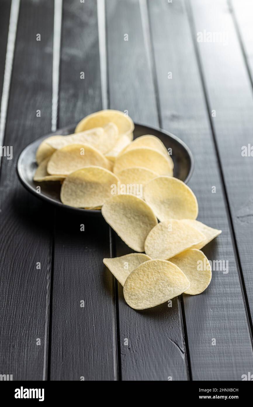 Crunchy potato chips. Potato crisps on black table Stock Photo - Alamy