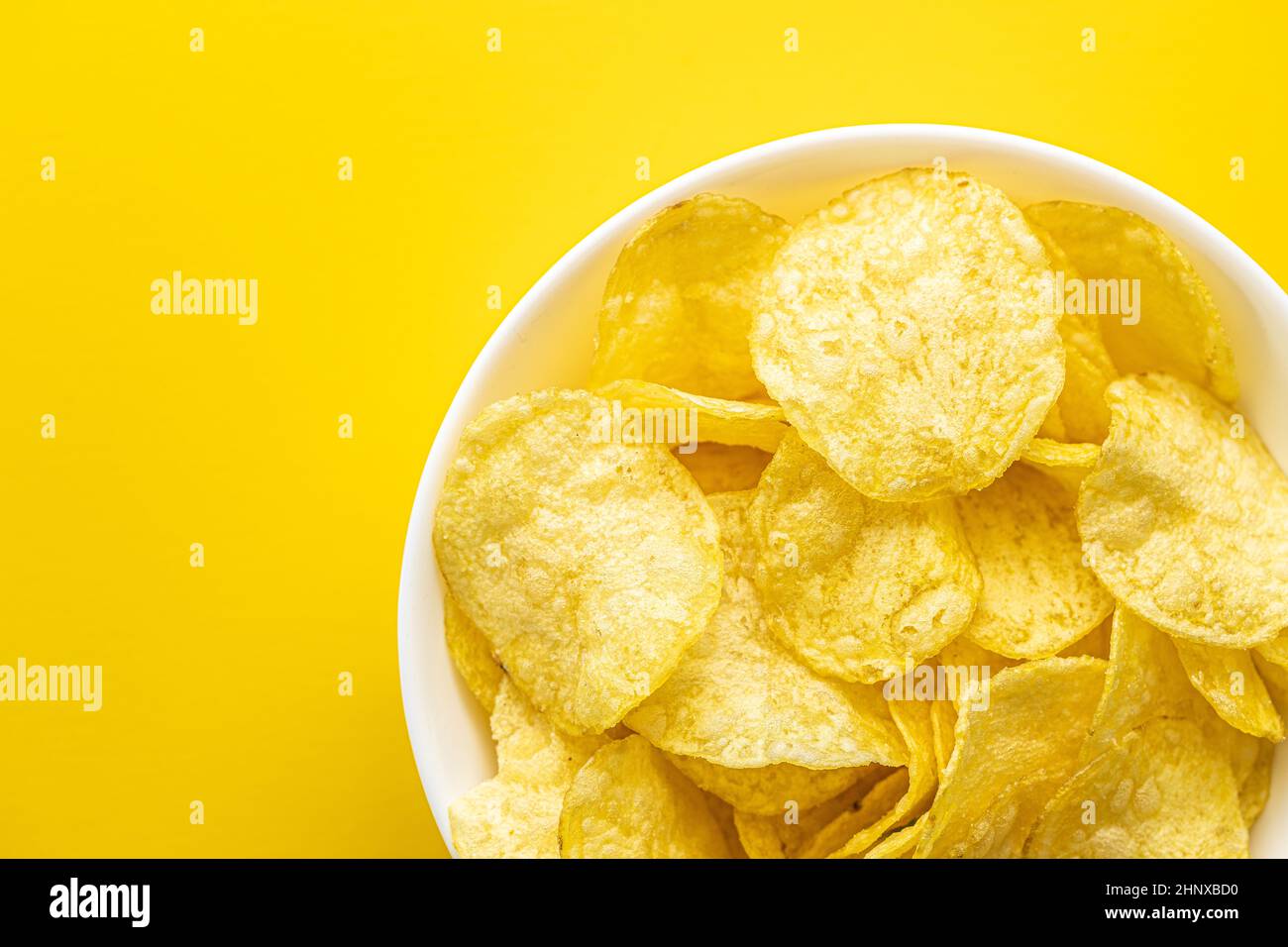 Crunchy potato chips. Potato crisps on yellow background. Top view ...