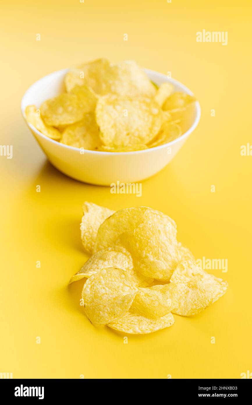 Crunchy potato chips. Potato crisps on yellow background Stock Photo ...