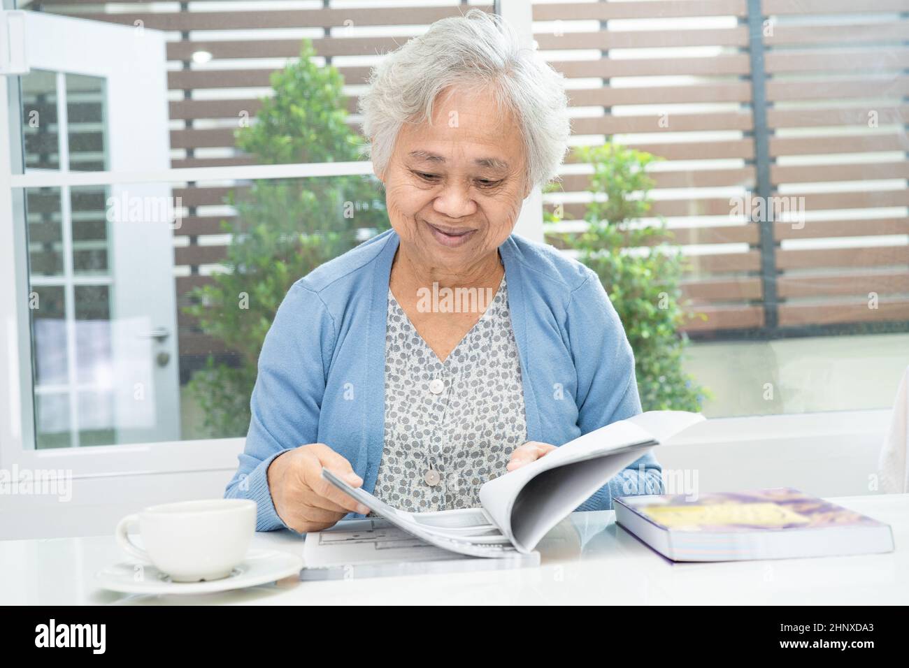 Asian senior or elderly old lady woman reading a book for practice ...