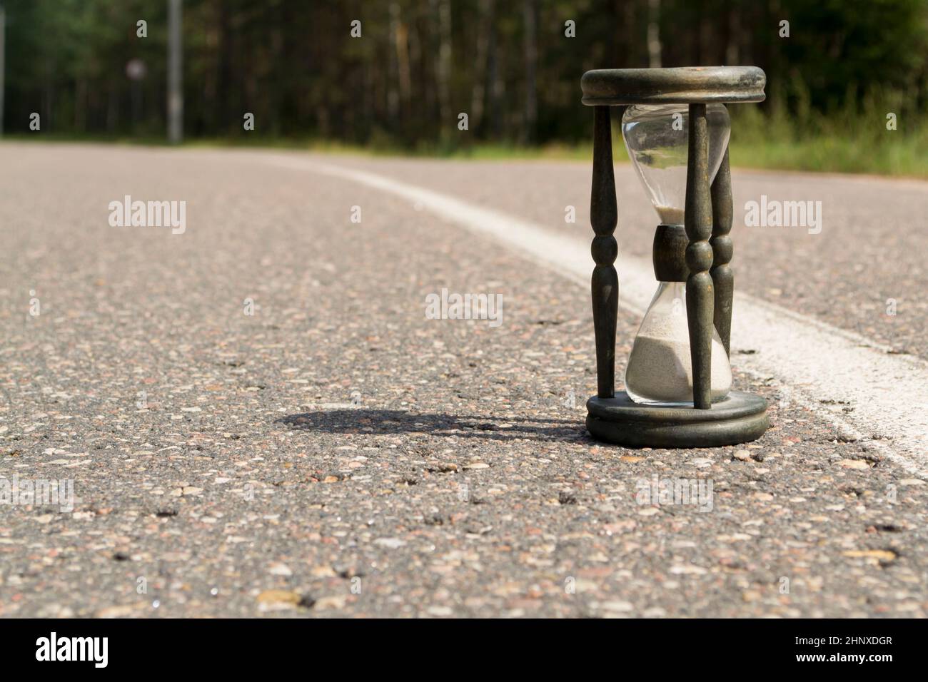 Time concept alarm hourglass on the asphalt road Stock Photo - Alamy