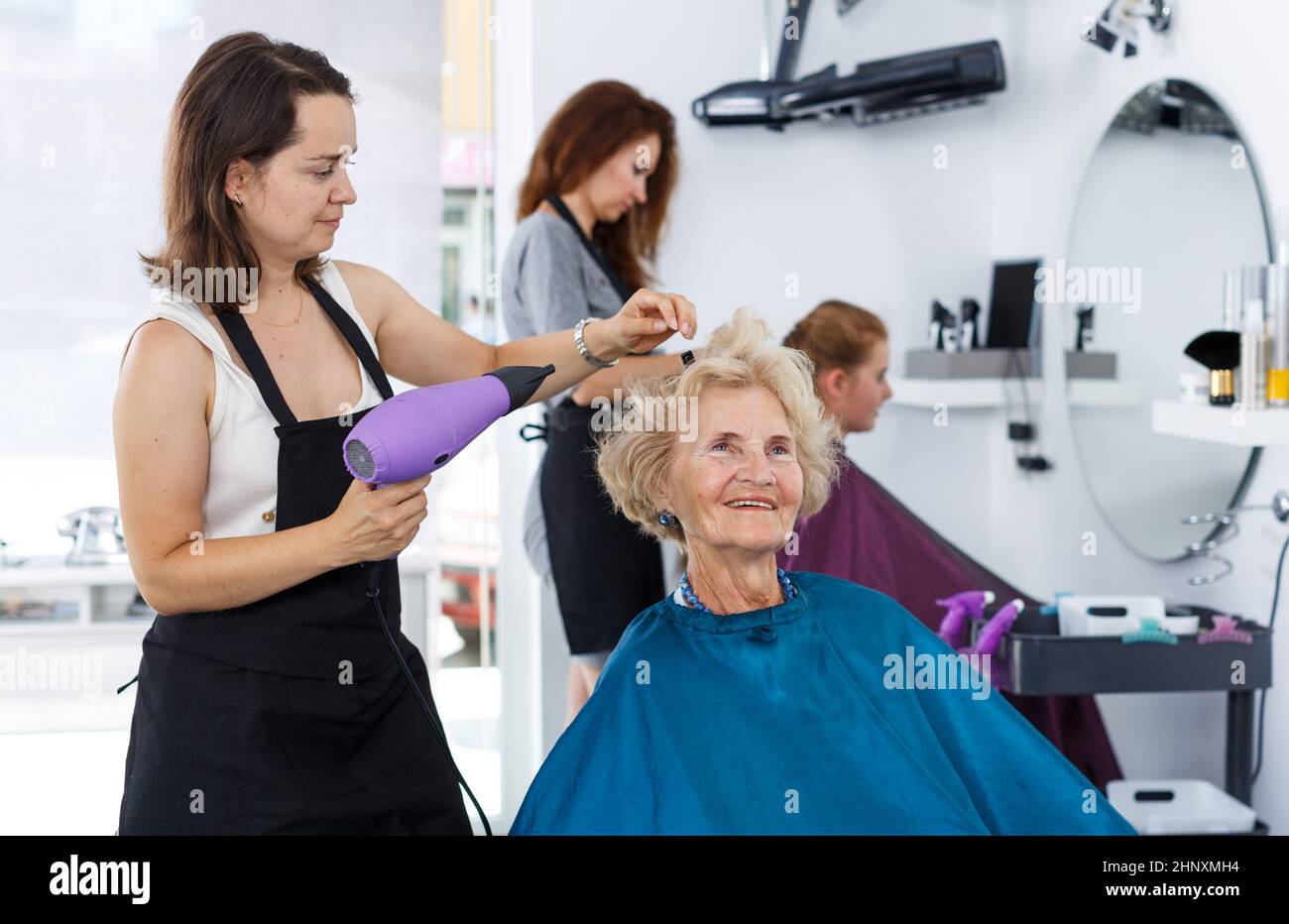 Barber styling hair using dryer hi-res stock photography and images - Alamy