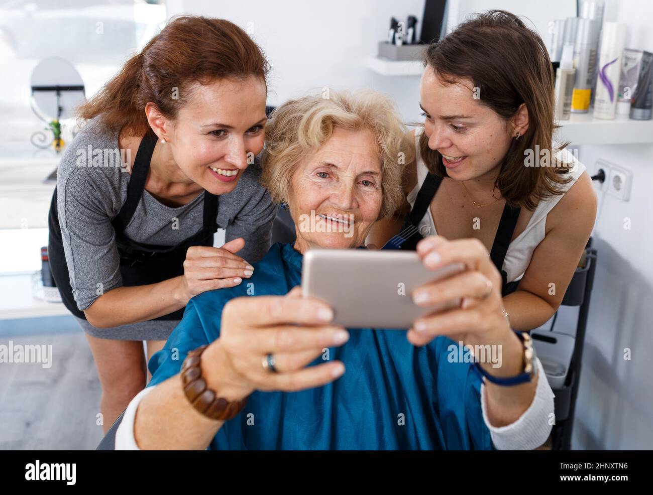 Hairstylists and female customer taking selfie Stock Photo - Alamy