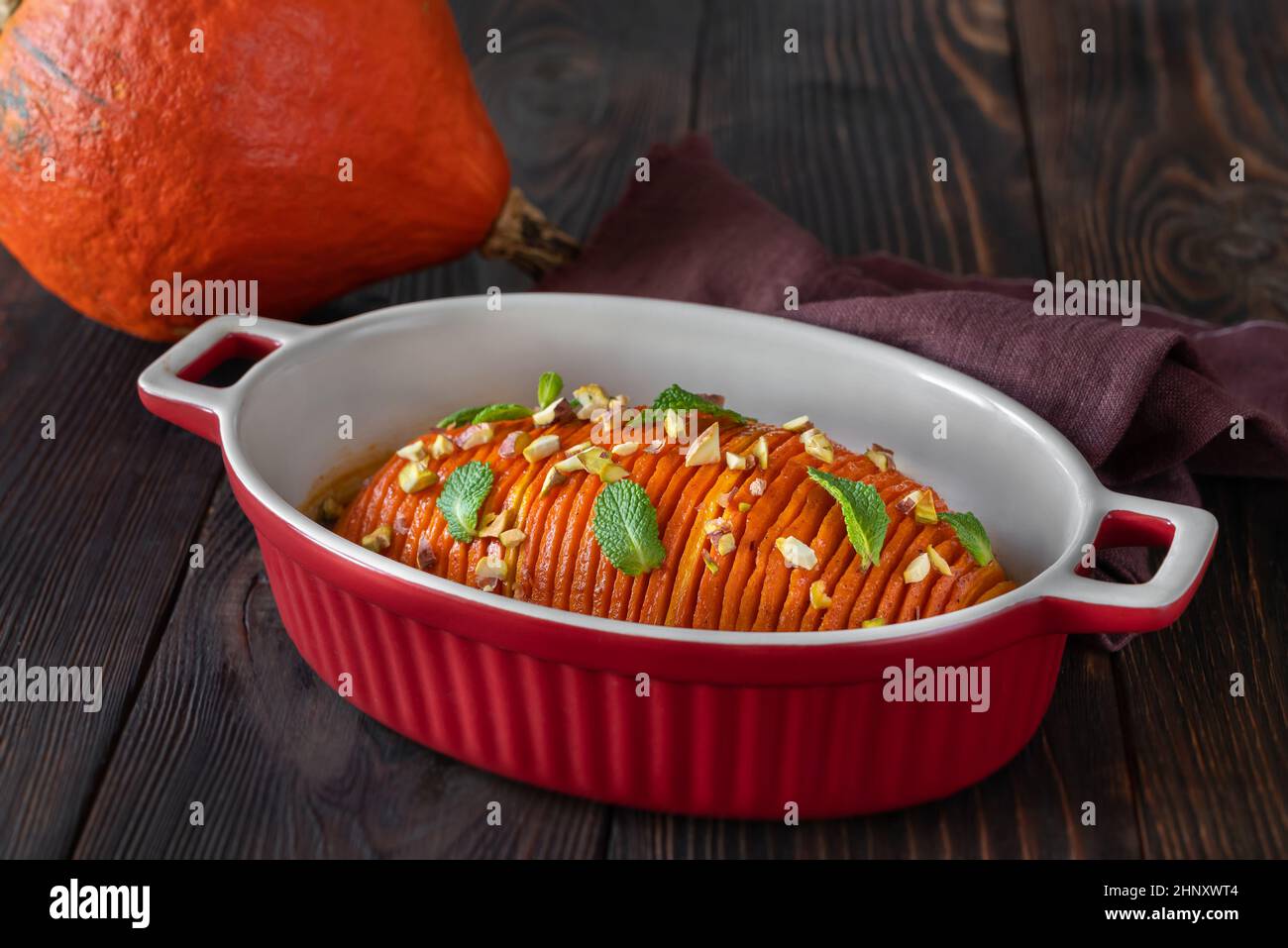 Baked hasselback pumpkin glazed with caramel in baking pan Stock Photo ...