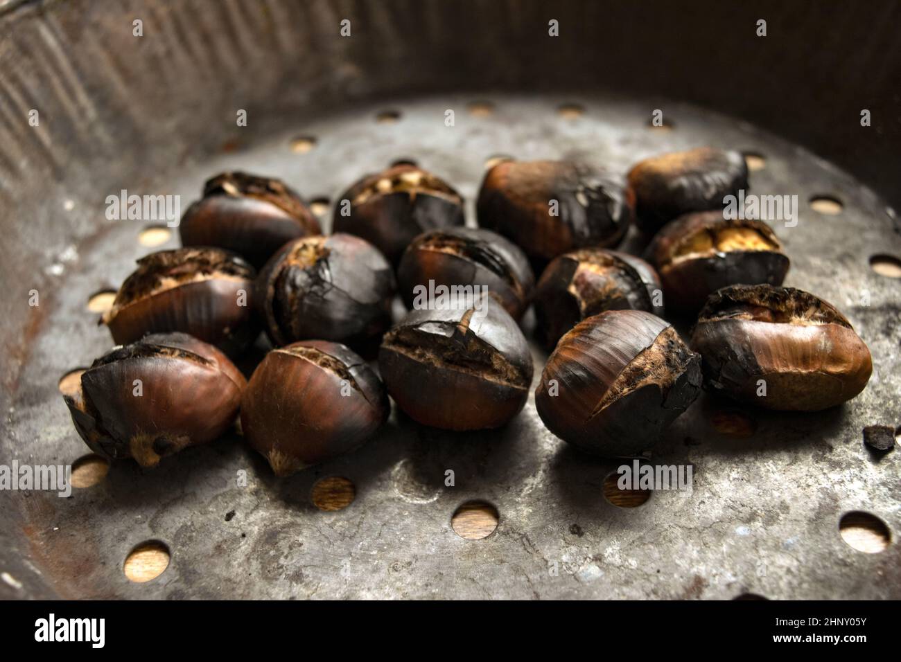roasted chestnuts in the typical perforated pan Stock Photo - Alamy