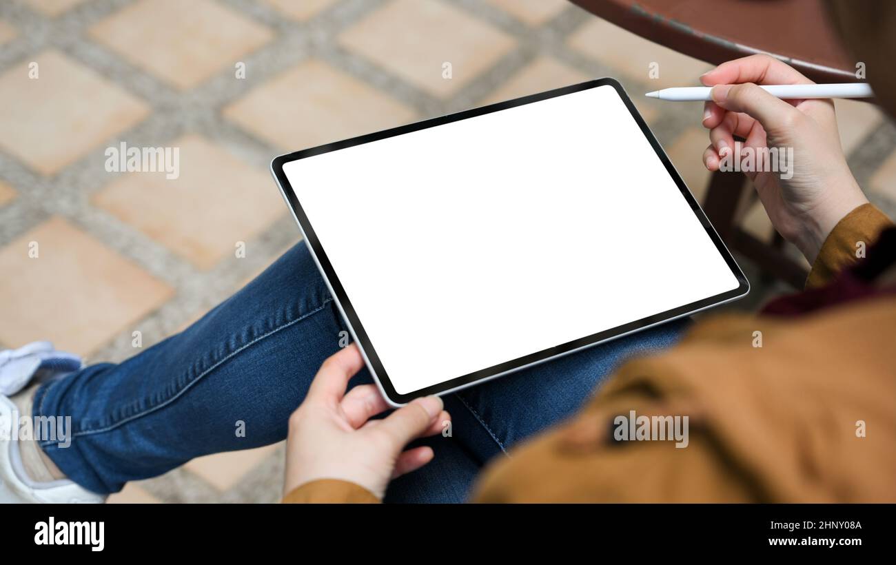 A female college student using a portable tablet computer with stylus ...