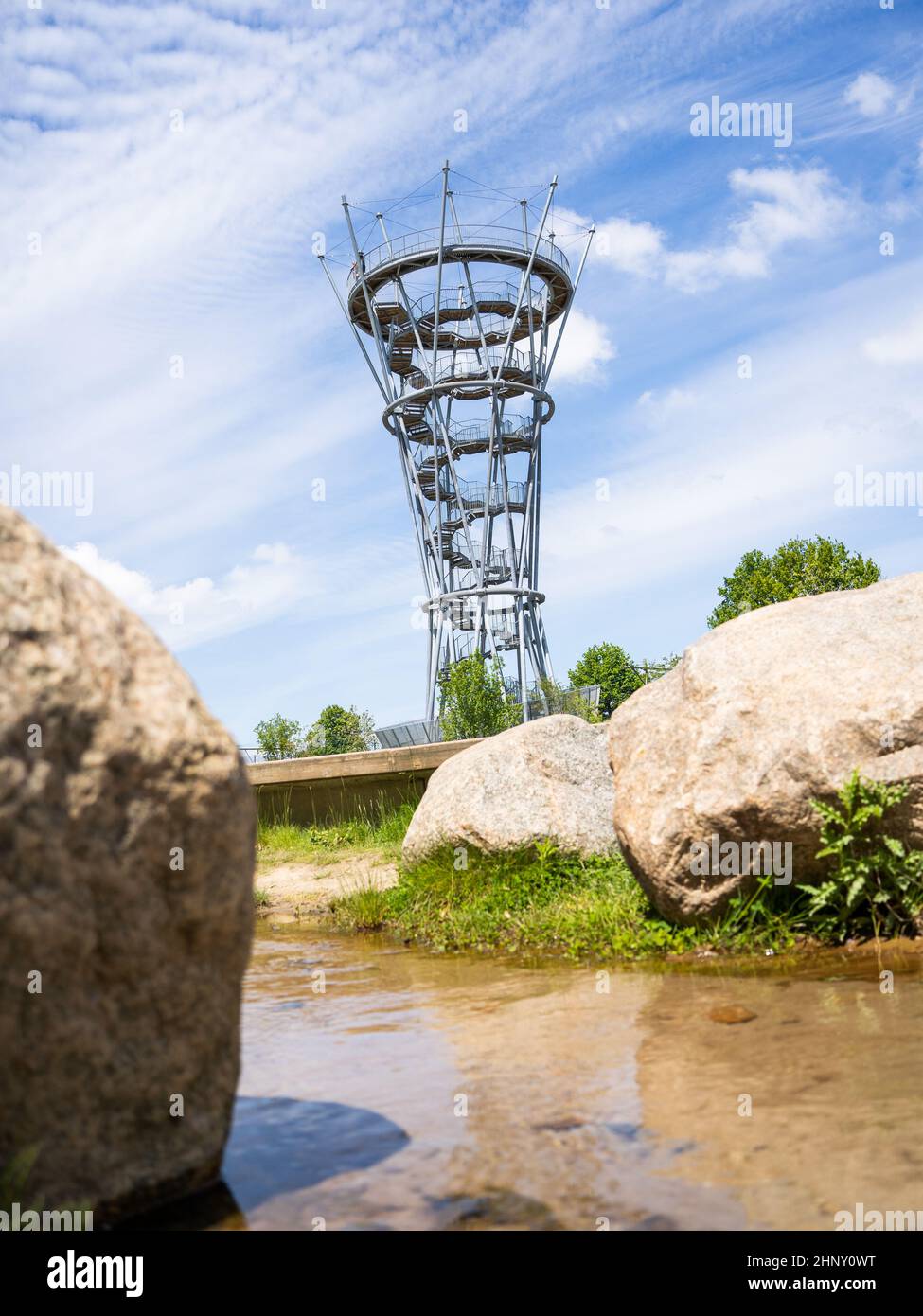 Modern watch tower with spiral elements against cloudy sky background ...