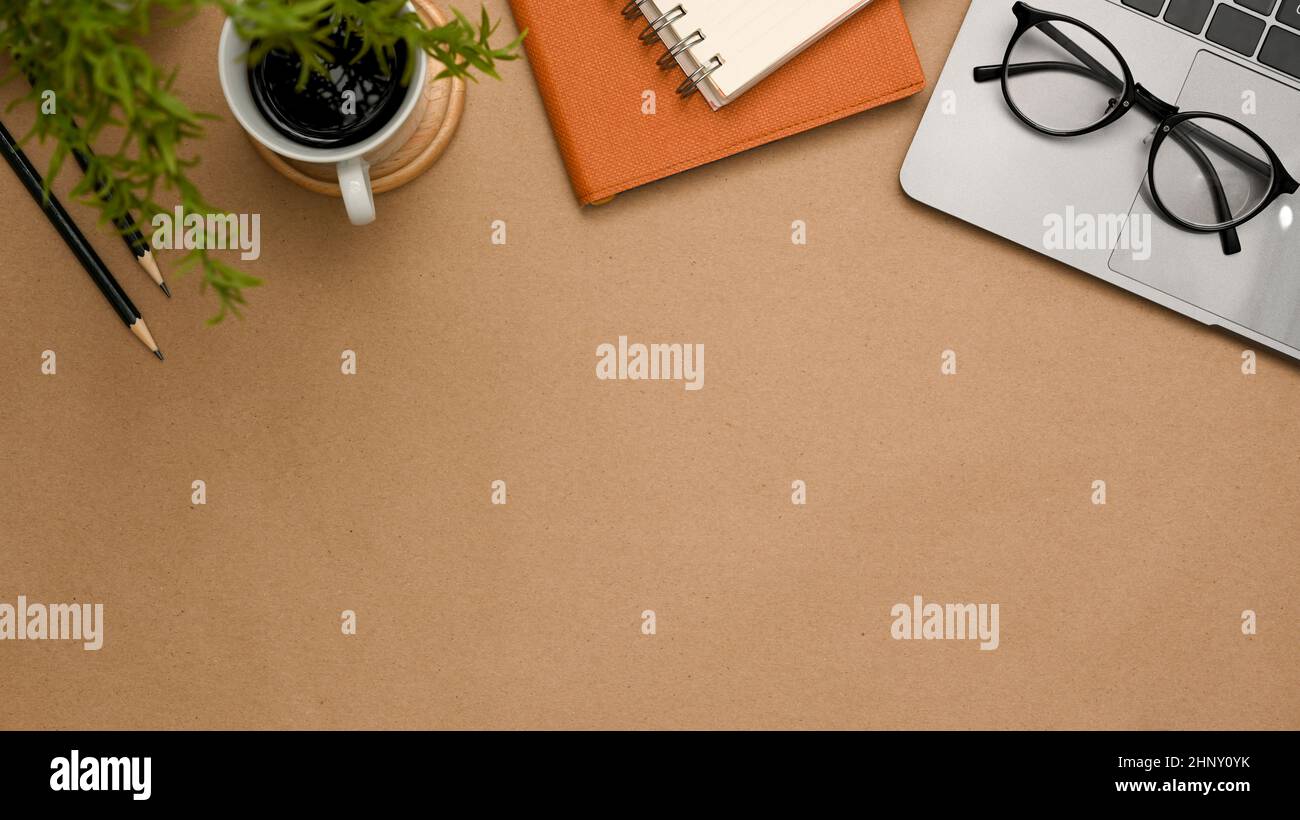 A brown workspace background with office supplies, laptop computer ...