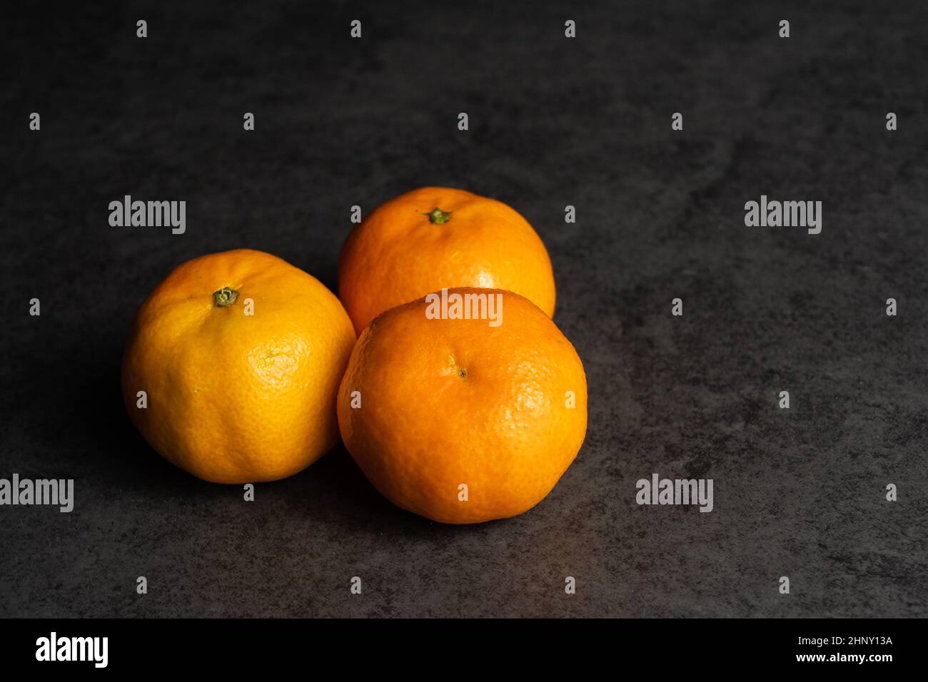 Three fresh tangerines on black background Stock Photo - Alamy
