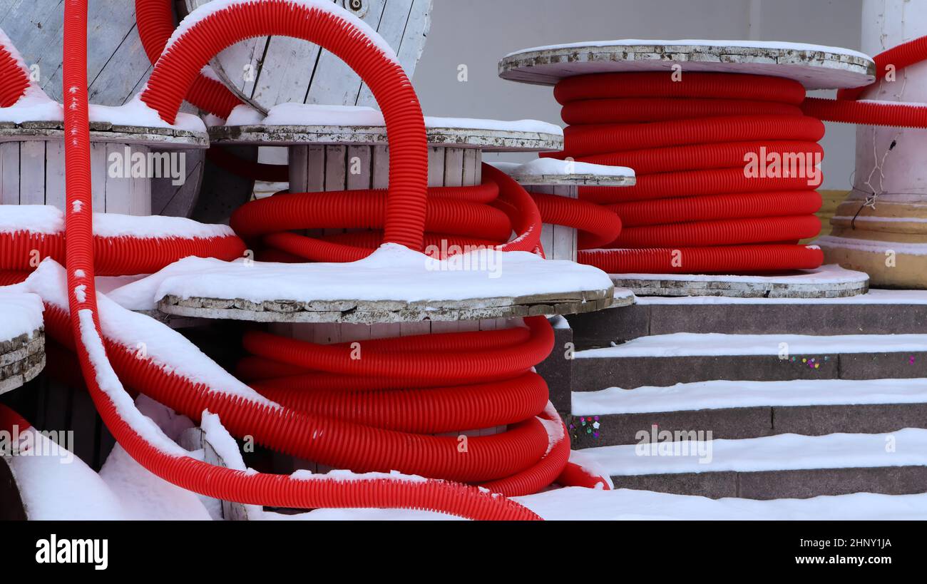 Large coils of red flexible corrugated pipe used to protect cables in ...