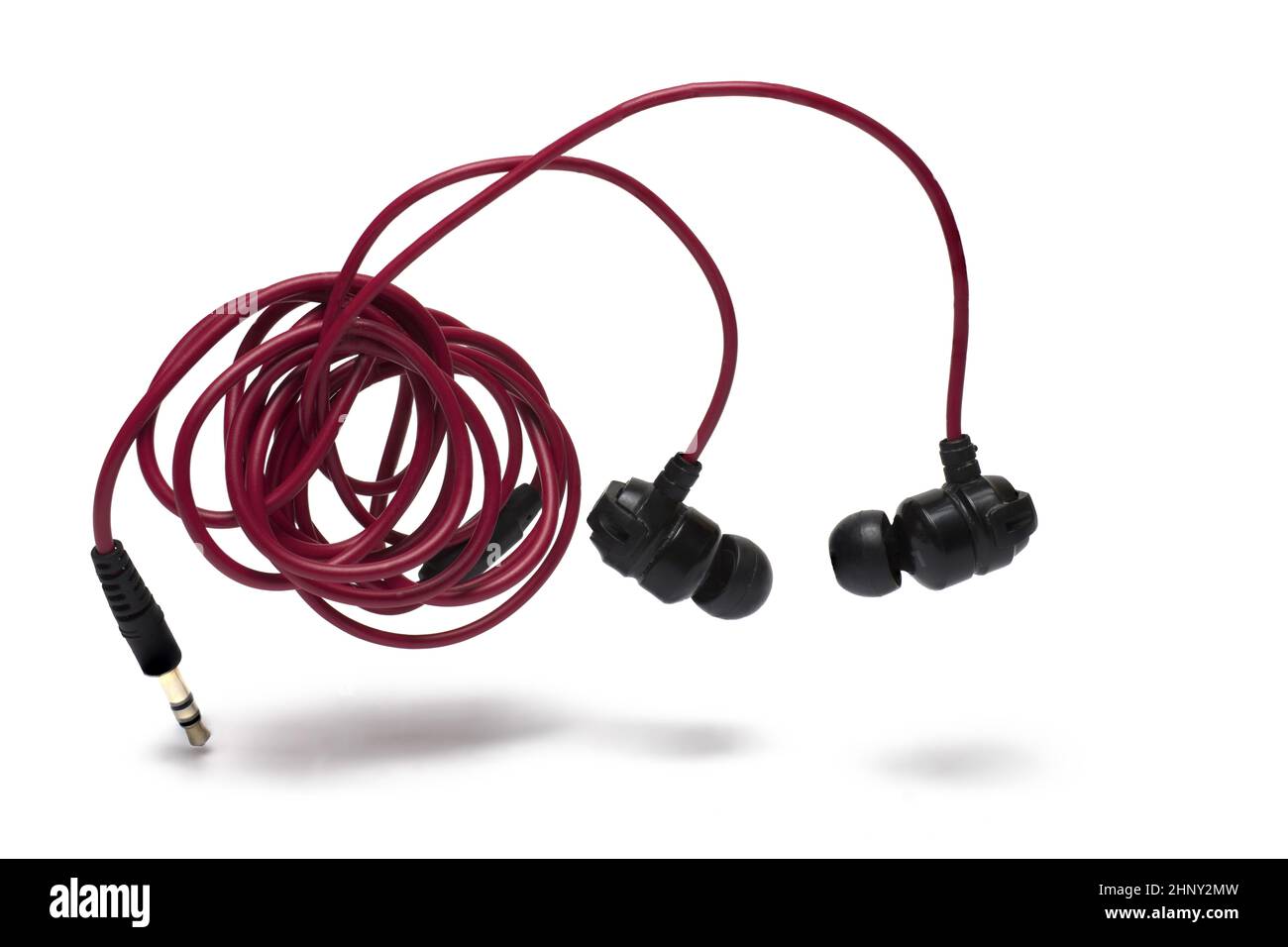 Close up of in ear headphones on red coiled cable with jack plug as ...