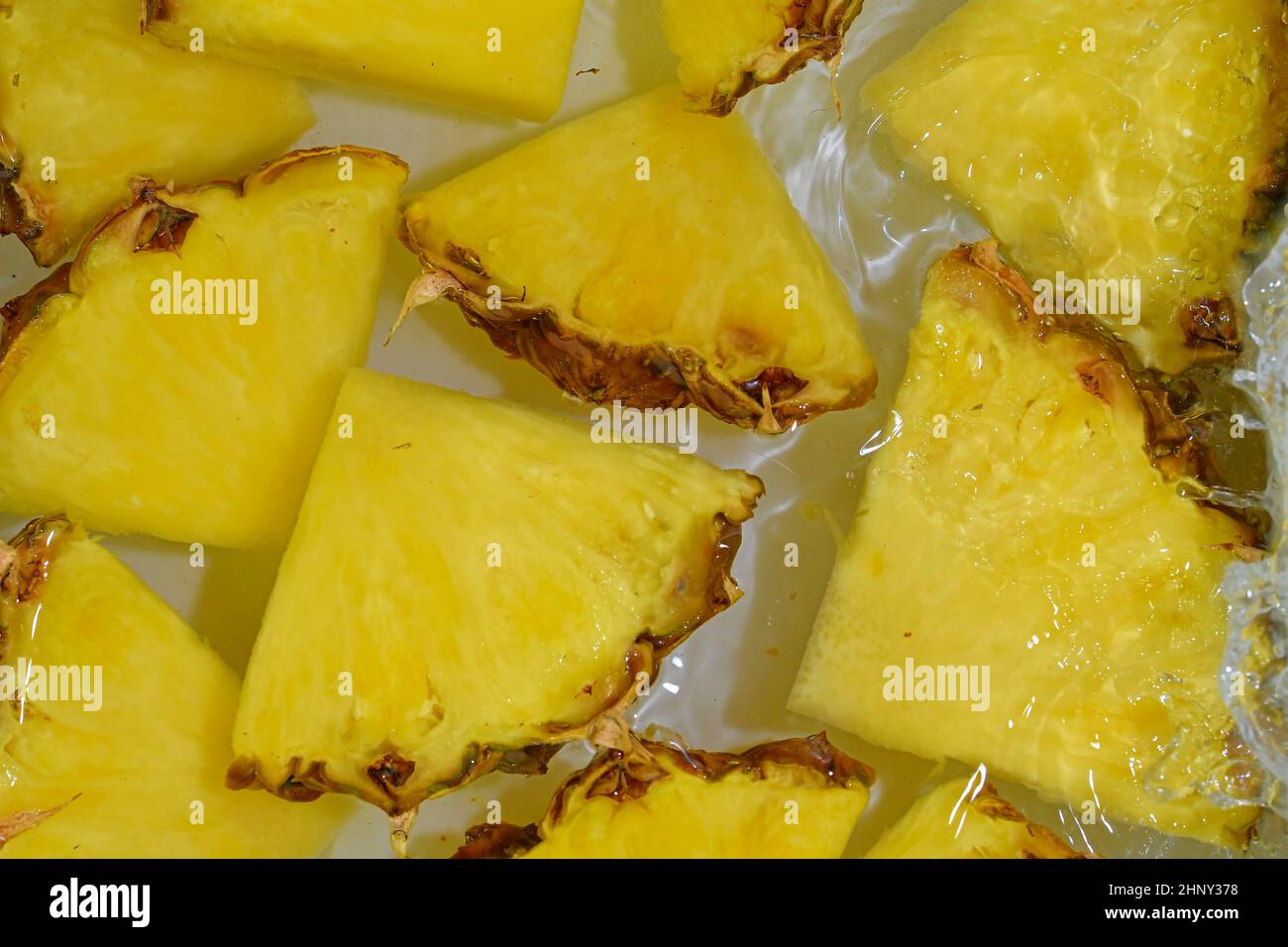 Slices of pineapple in water on white background. Pineapple close-up in ...