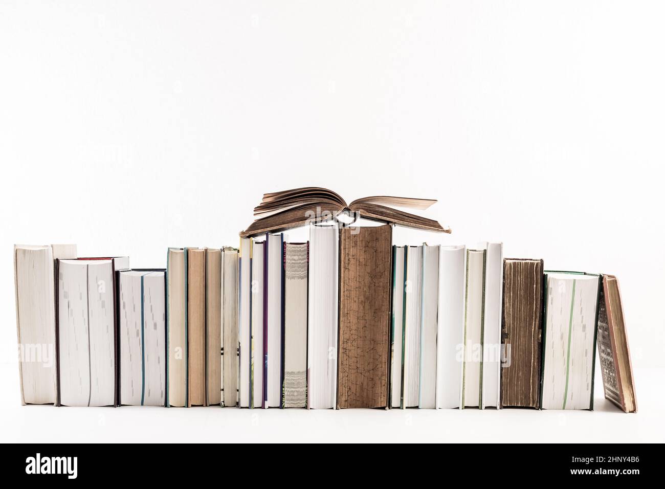 Assortment of new and old books in a row isolated on white background ...
