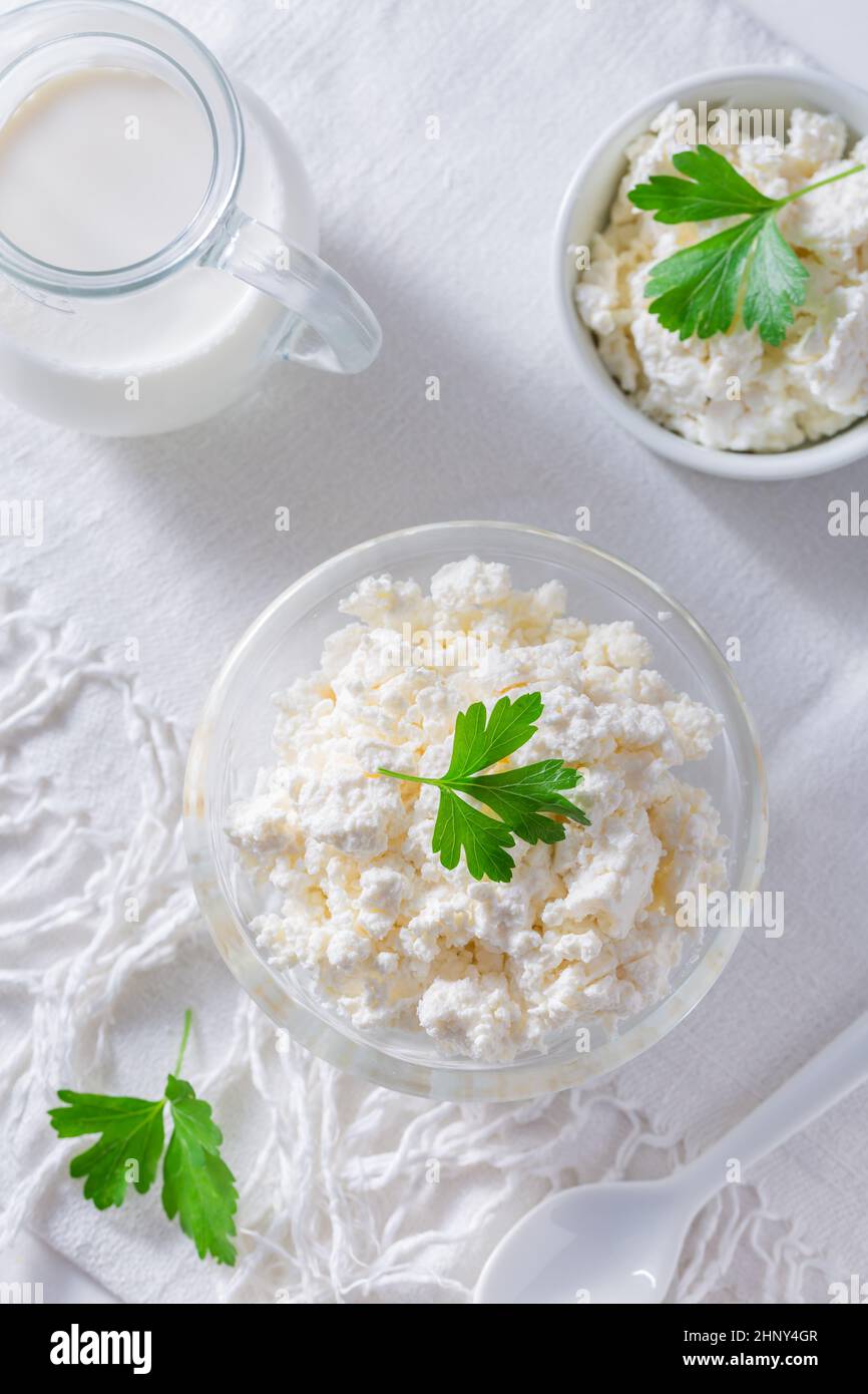 Dairy product - curd or cottage cheese, quark in bowl and milk on white ...