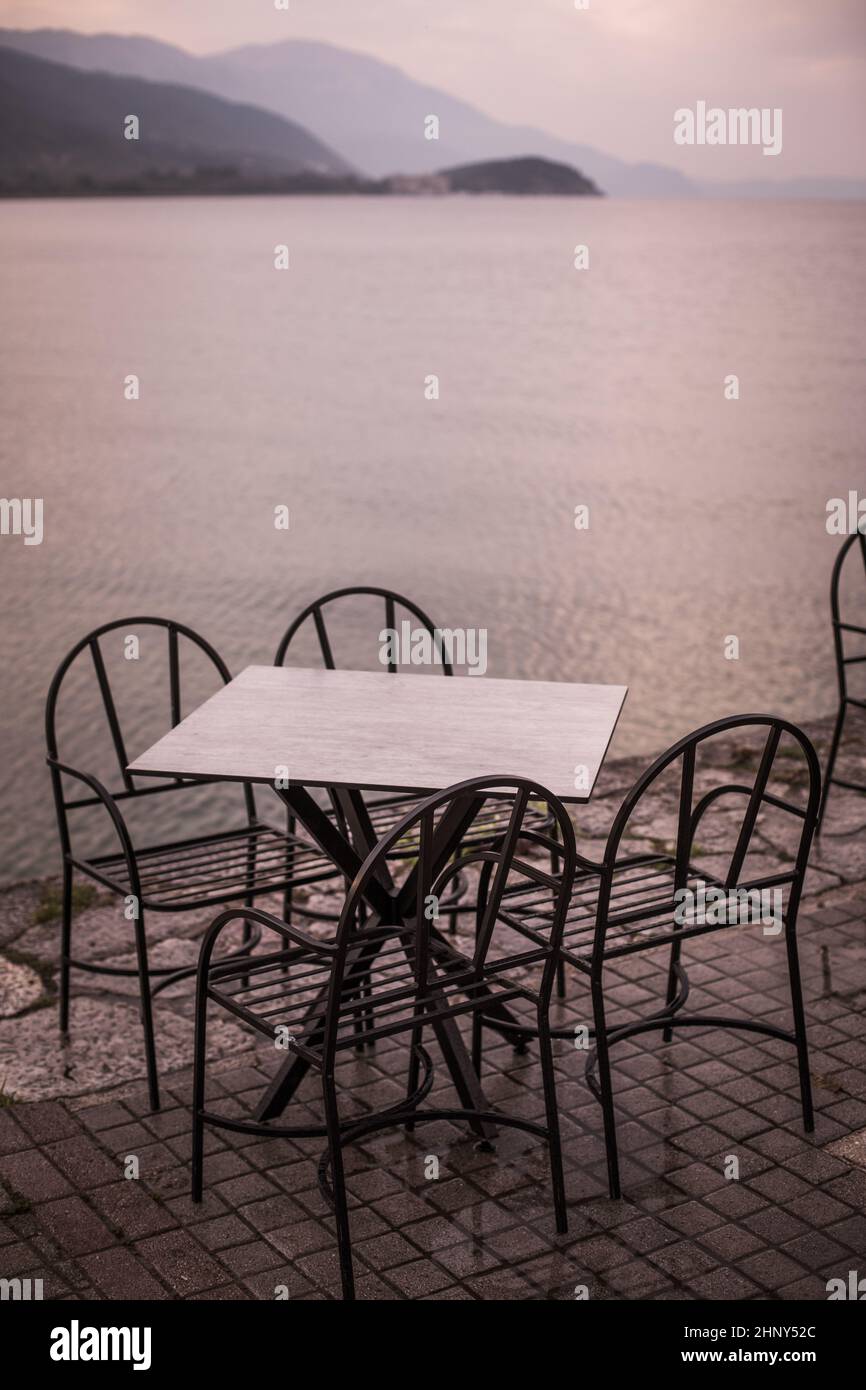 Color image of empty chairs and tables at an open air terrace, near a ...