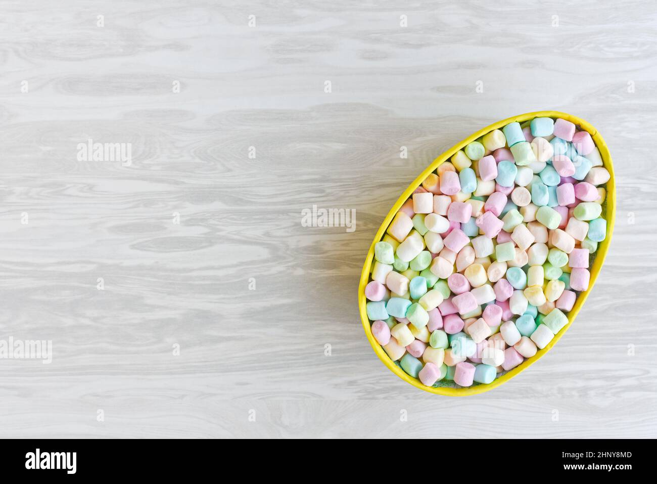 Top view of decorative Easter egg and multi colored mini marshmallows ...