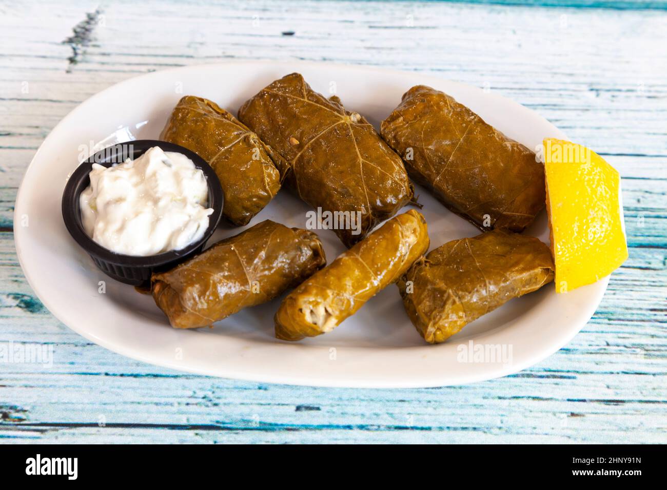 Greek Dolmadakia with tzatziki and lemon Stock Photo - Alamy
