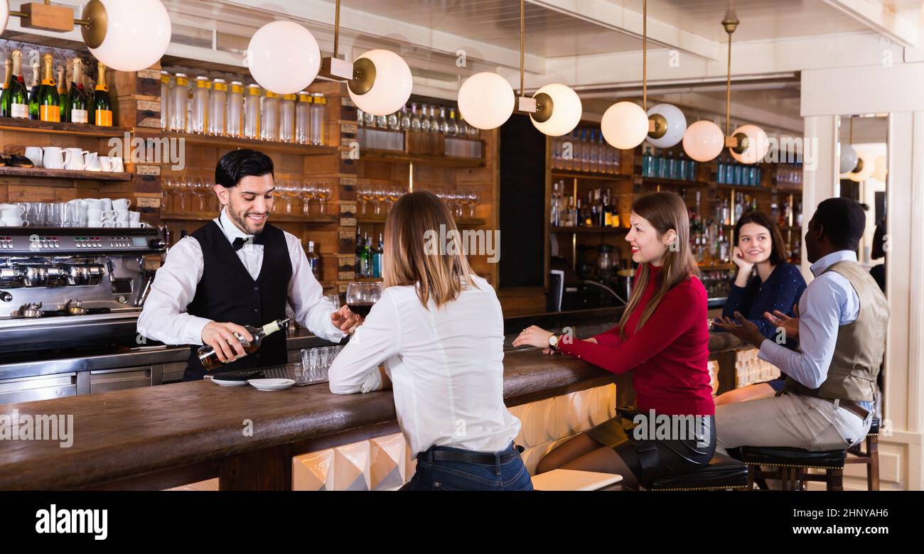 Portrait of barman and people who are standing near bar counter in ...