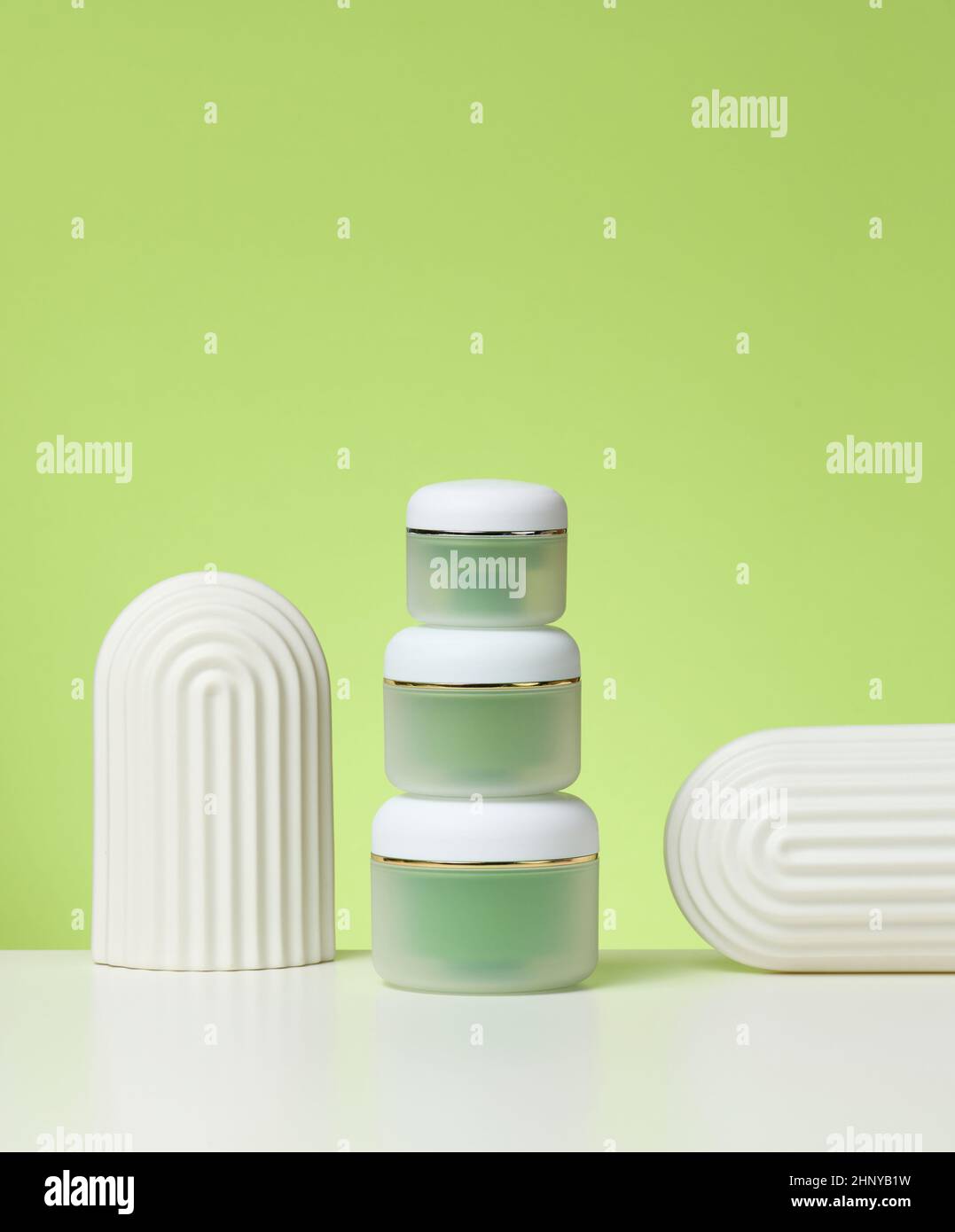 green jar for cosmetics on a white table. Packaging for cream, gel ...