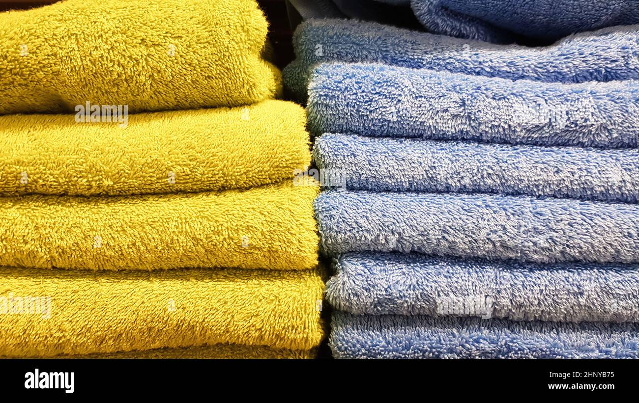 Stacks of fluffy bath towels of various colors in a store window. Terry ...