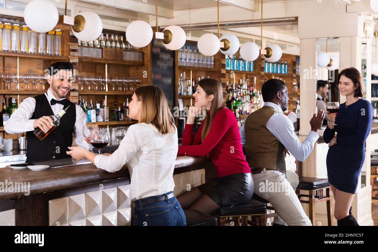 Portrait of barman and people who are standing near bar counter in ...
