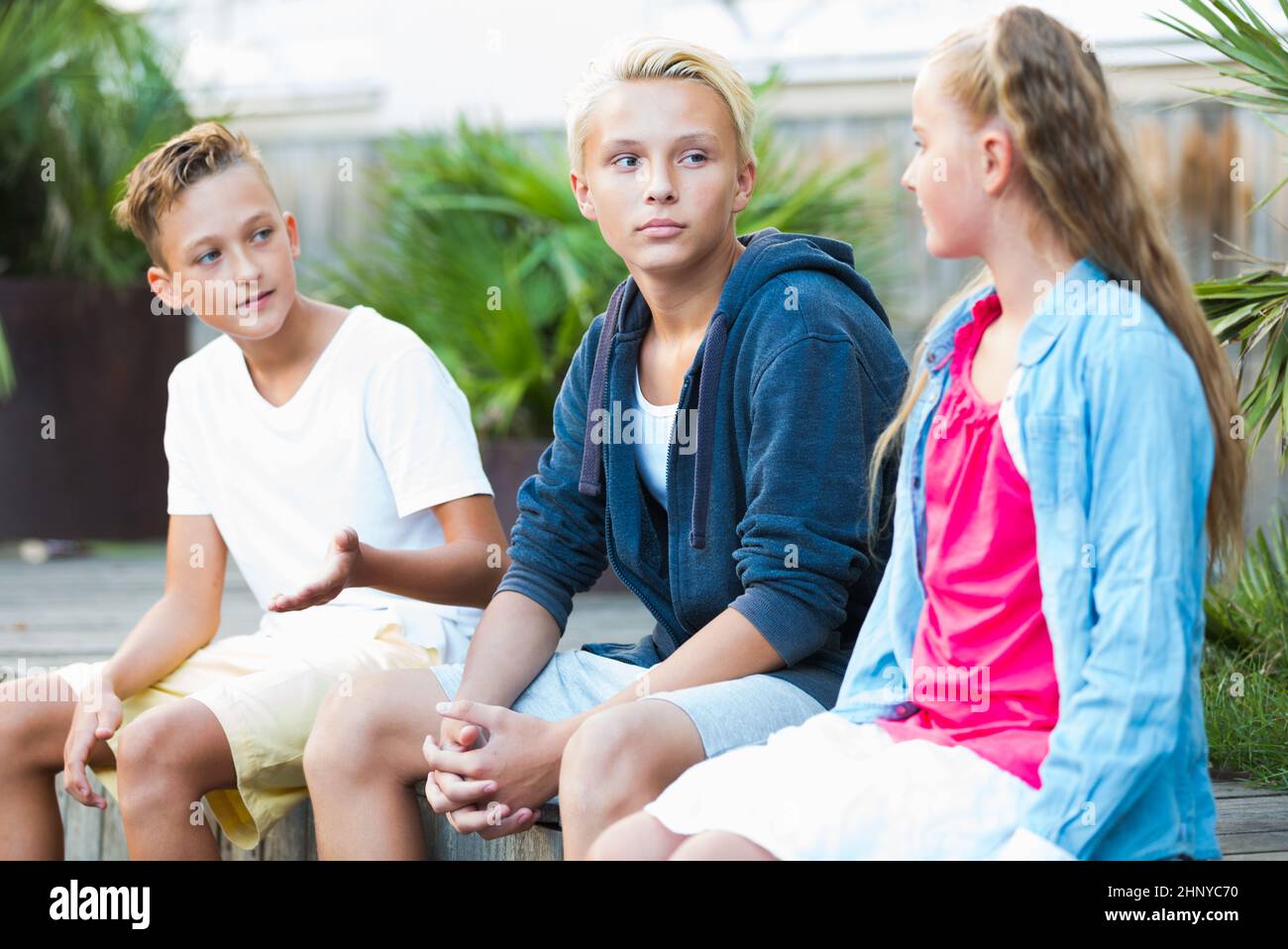 Happy kids having conversation outdoors Stock Photo - Alamy