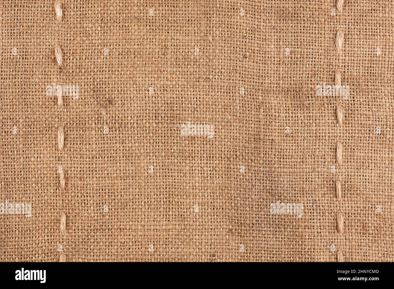 The two vertical stitching on the burlap as background Stock Photo - Alamy