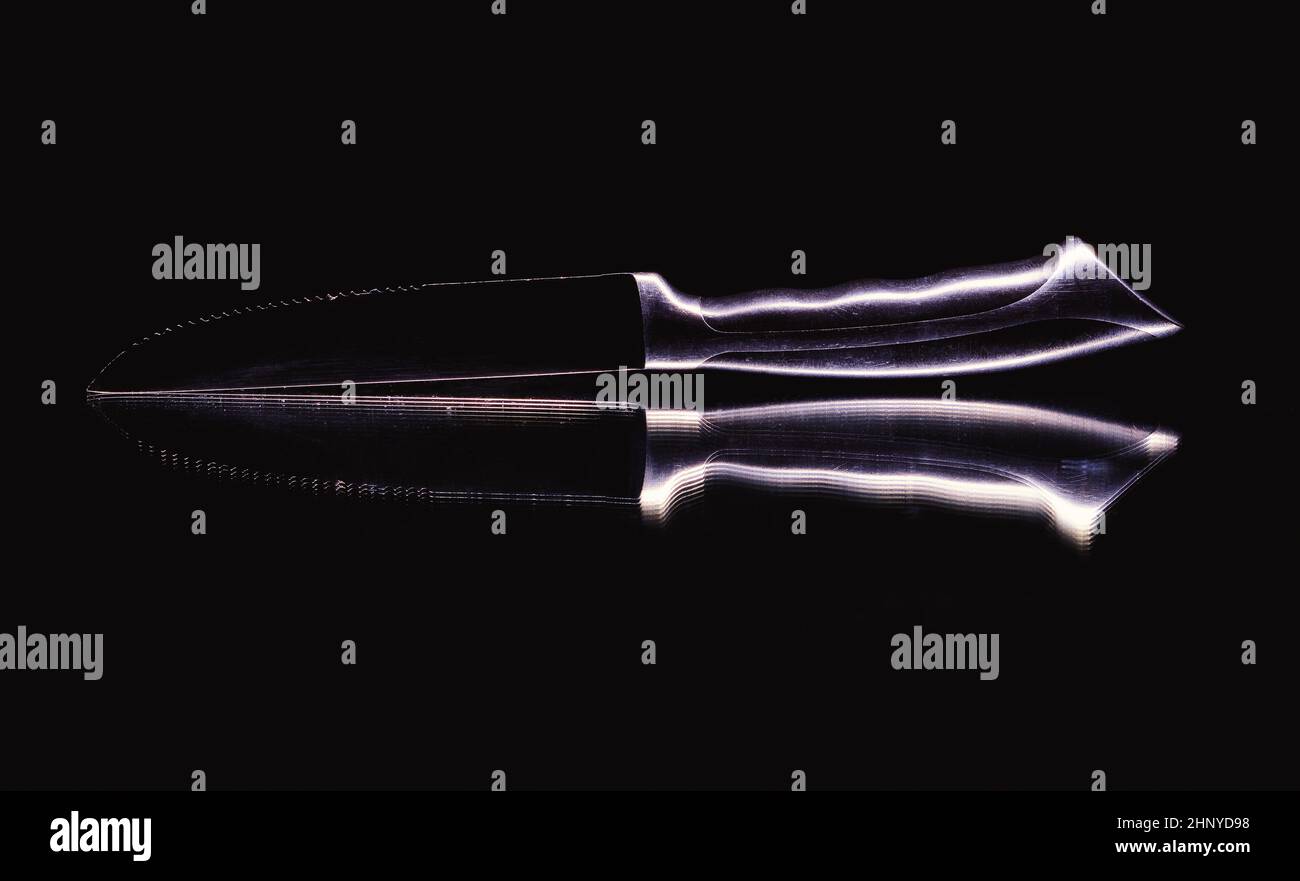 One kitchen knife on mirror on black background Stock Photo - Alamy