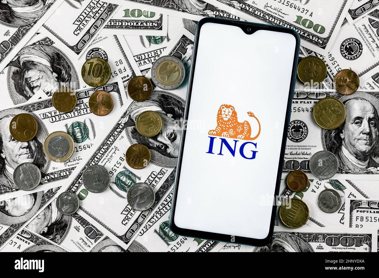 Smartphone with ING Group logo surrounded by variety of metal coins on ...