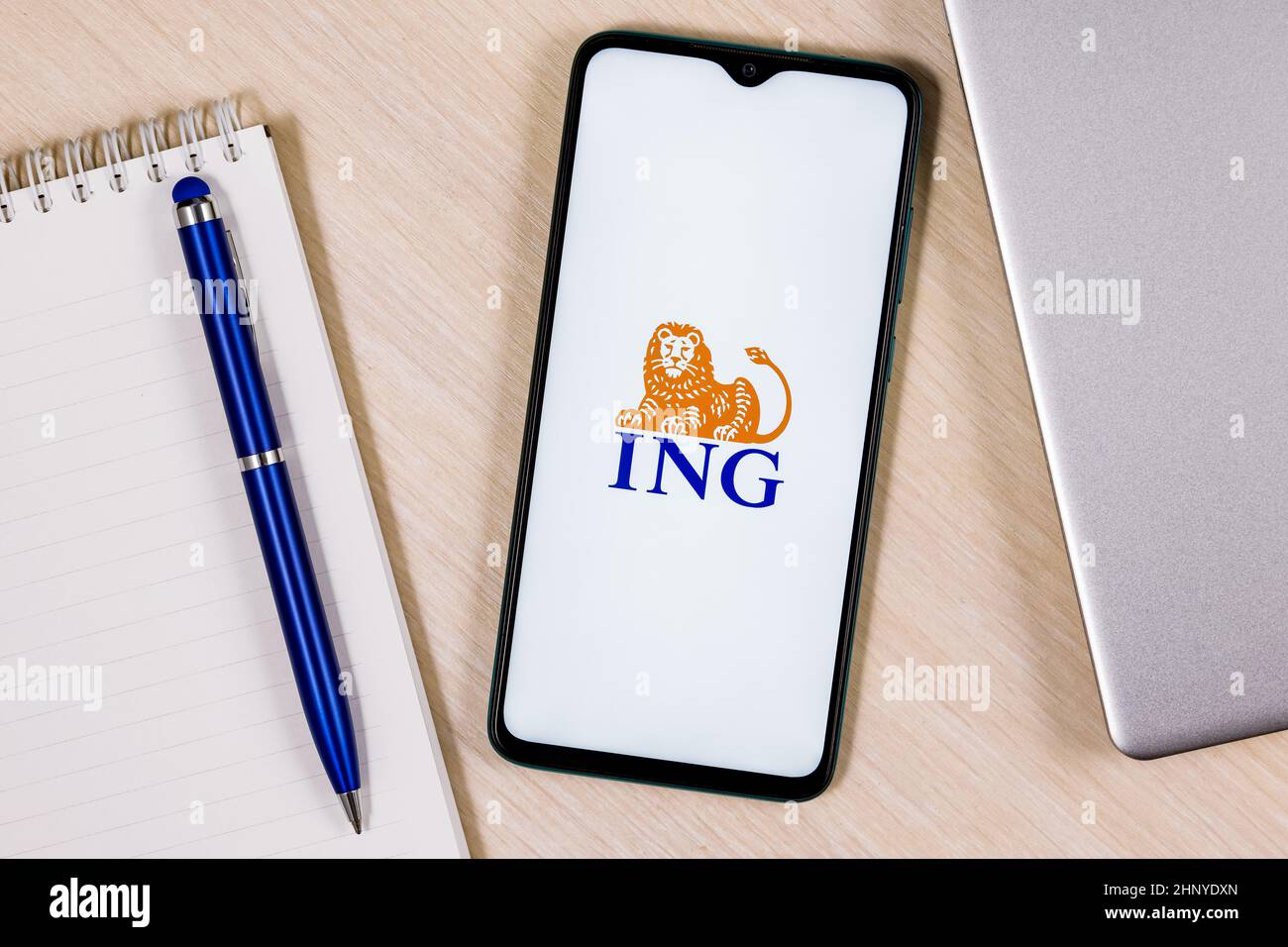 Smartphone with ING Group logo surrounded by variety of metal coins on ...
