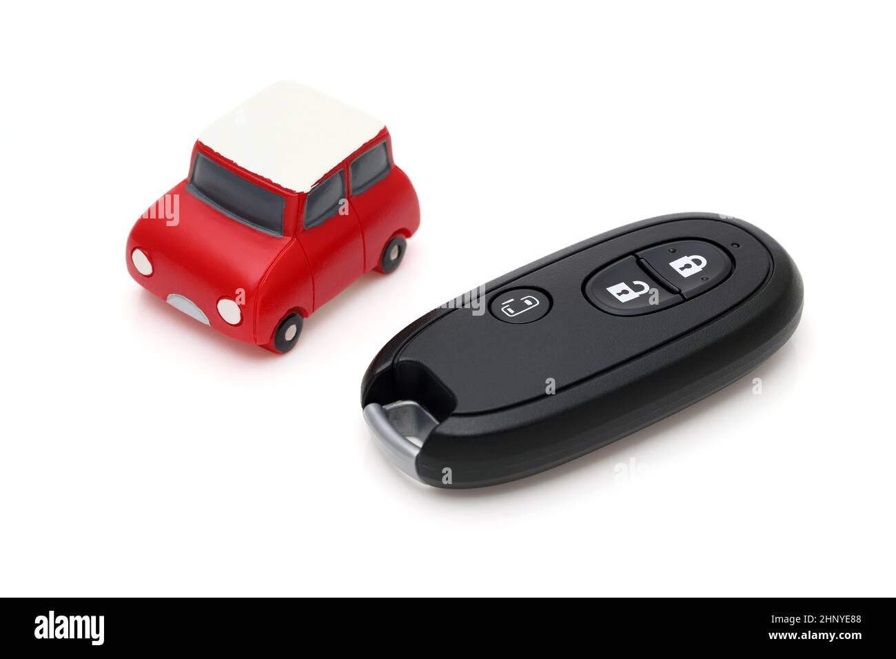 Car black key remote controller and small toy car on white background ...
