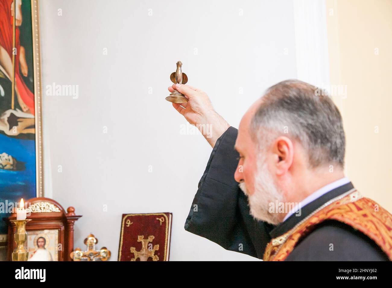 An Armenian priest holds a bird figurine in his hand and performs the ...