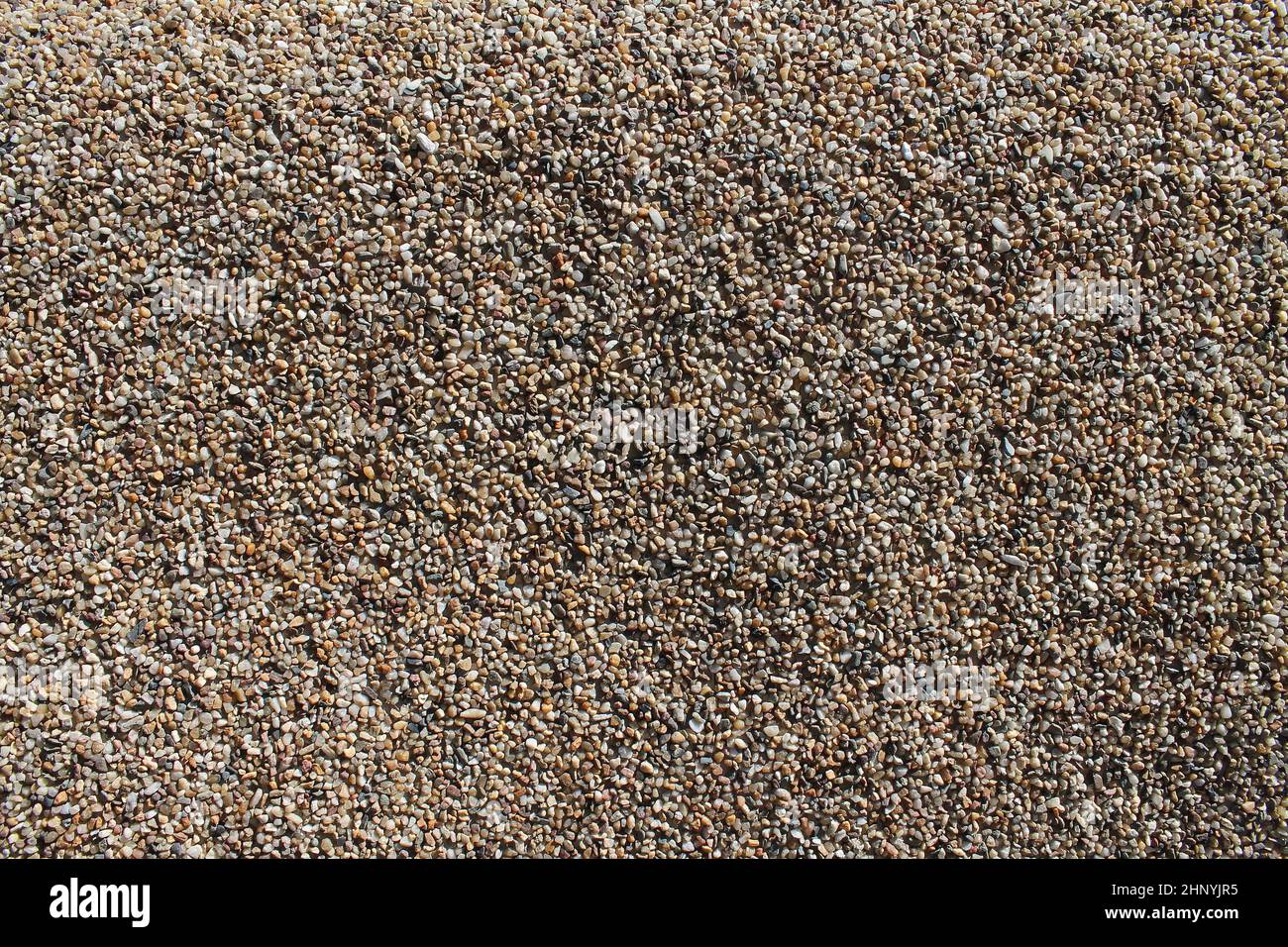 Detailed close up view on pebbles and stones on a gravel ground texture ...