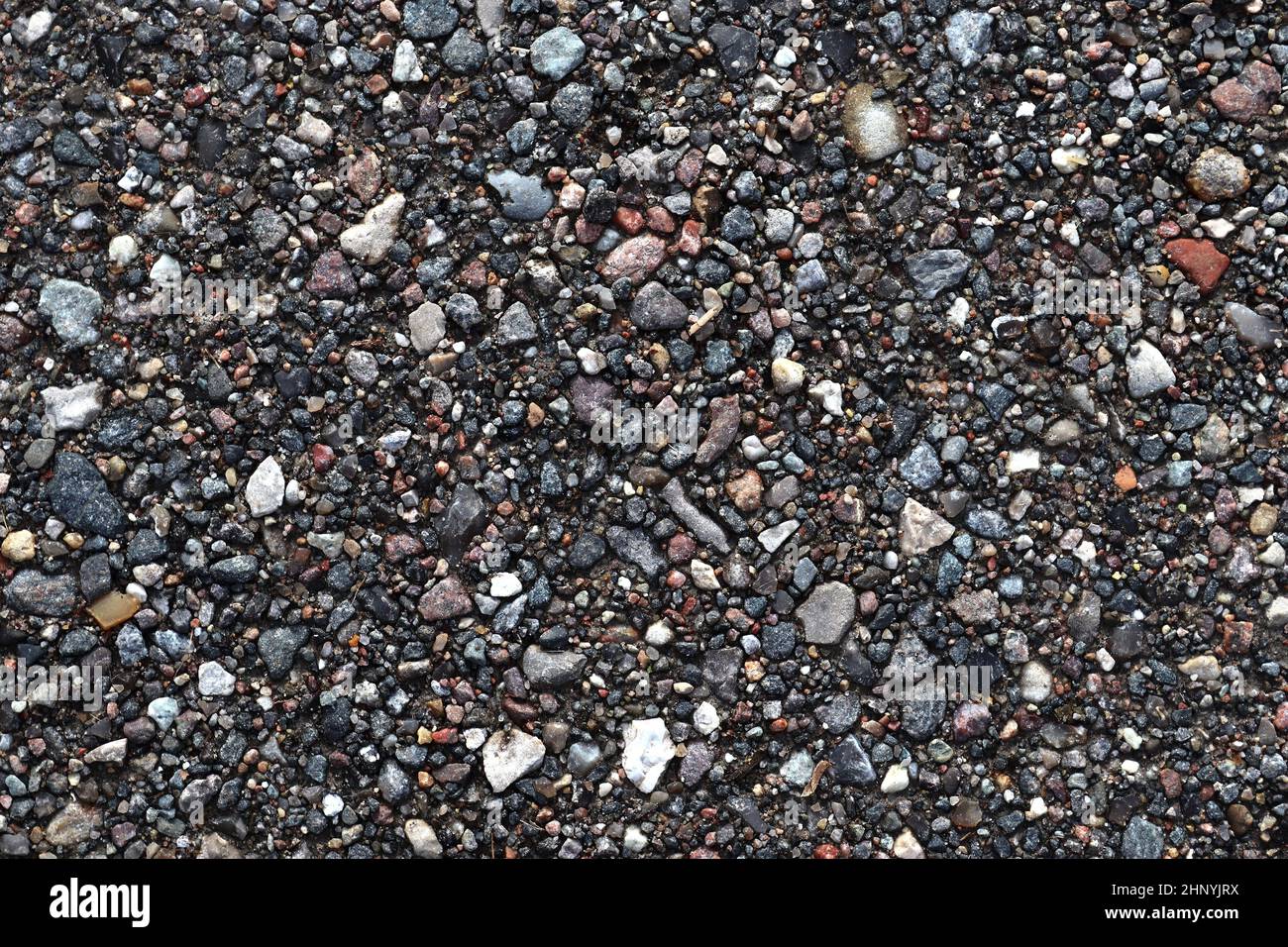 Detailed close up view on pebbles and stones on a gravel ground texture ...