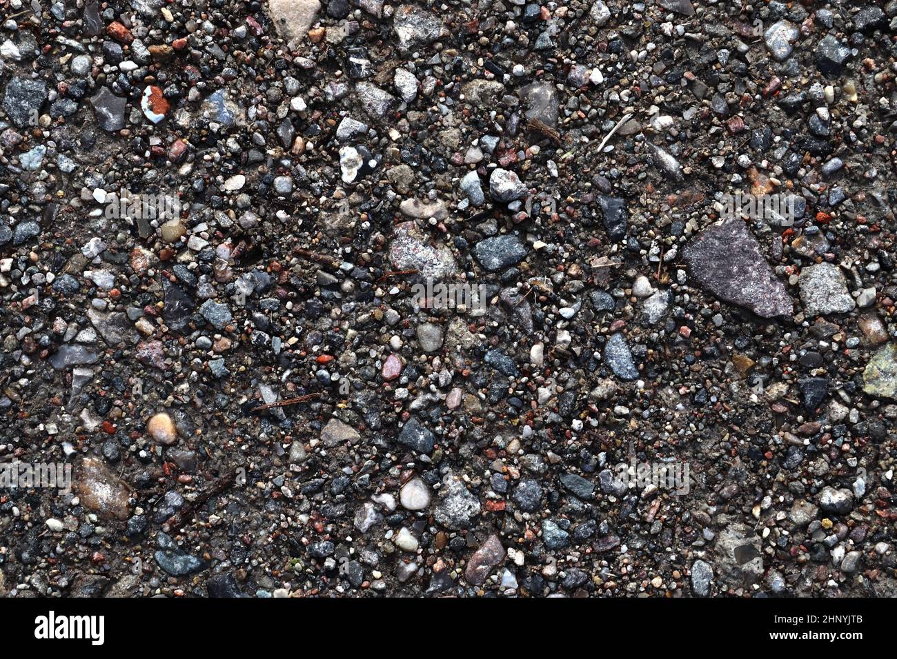 Detailed close up view on pebbles and stones on a gravel ground texture ...