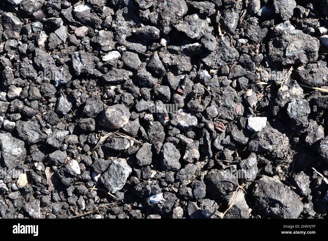 Detailed close up view on pebbles and stones on a gravel ground texture ...