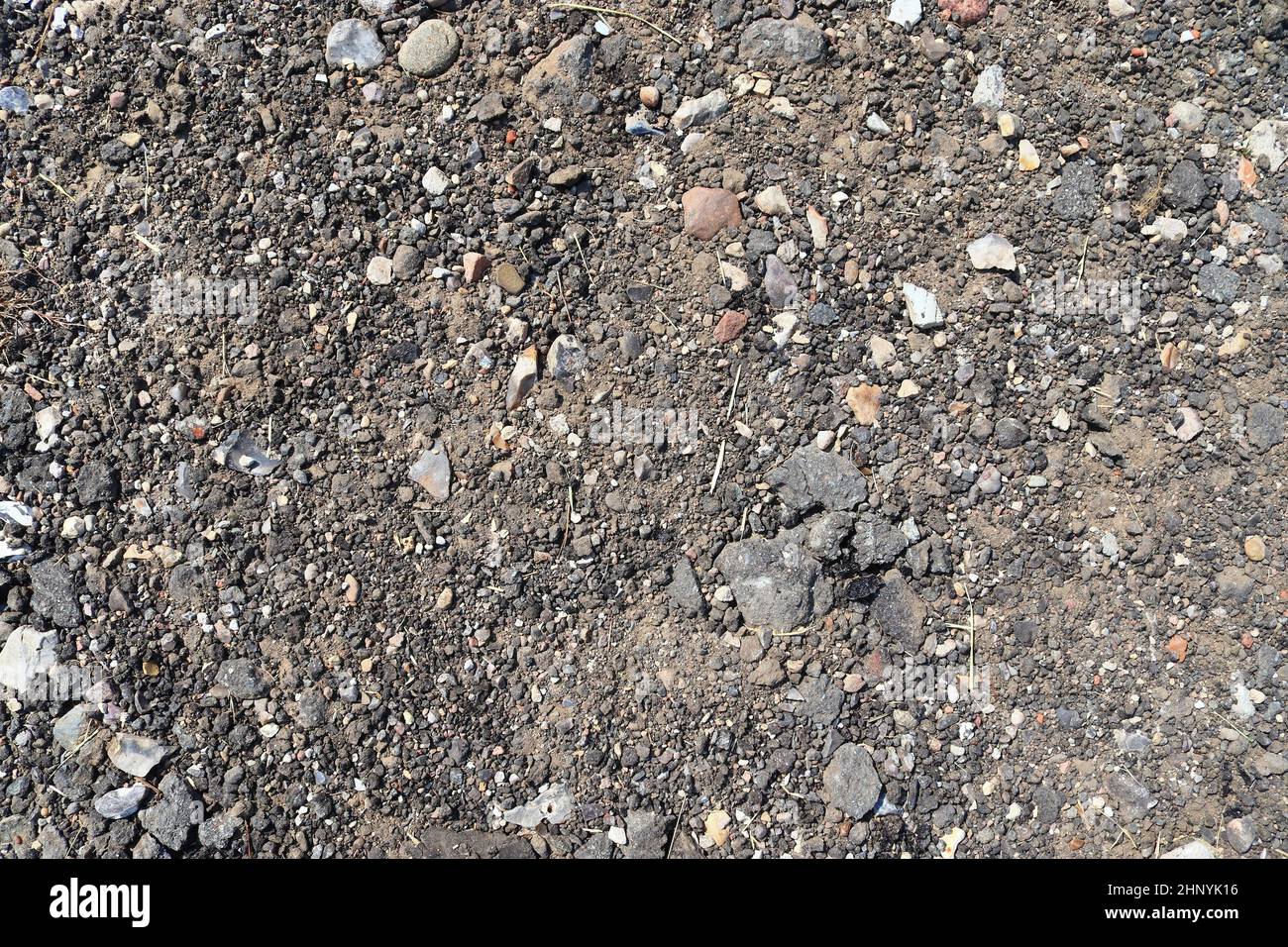 Detailed close up view on pebbles and stones on a gravel ground texture ...