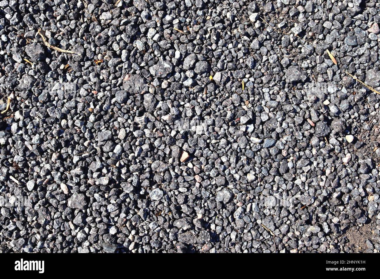 Detailed close up view on pebbles and stones on a gravel ground texture ...