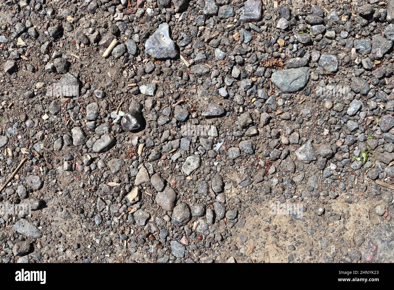 Detailed close up view on pebbles and stones on a gravel ground texture ...